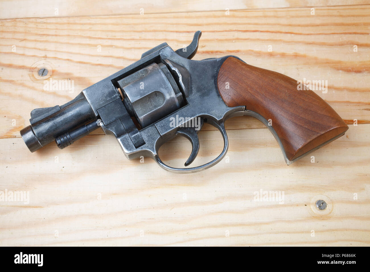 Revolver on the wooden table background Stock Photo - Alamy