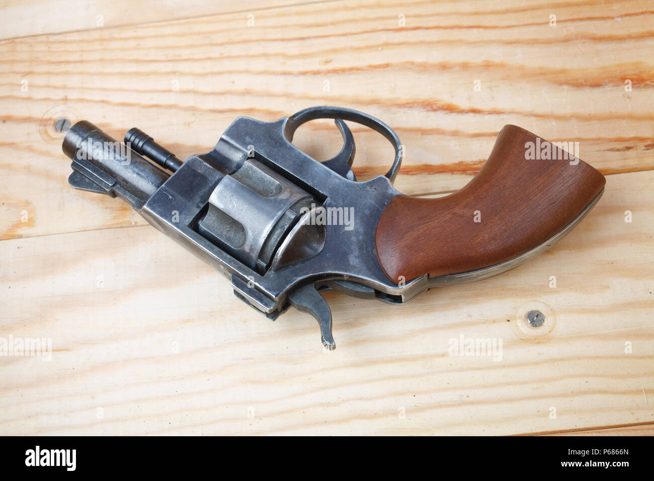Revolver on the wooden table background Stock Photo - Alamy