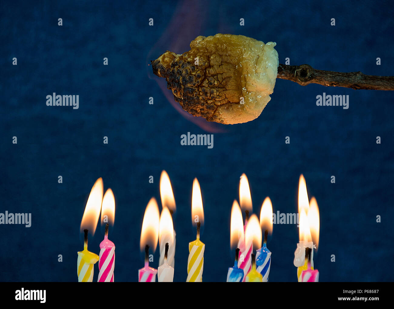 roasting marshmallow on a stick over many flaming birthday candles ...
