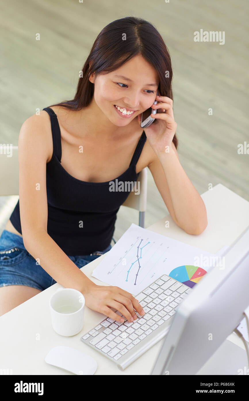 One Young Chinese Woman Working in the Home office with Computer Stock ...