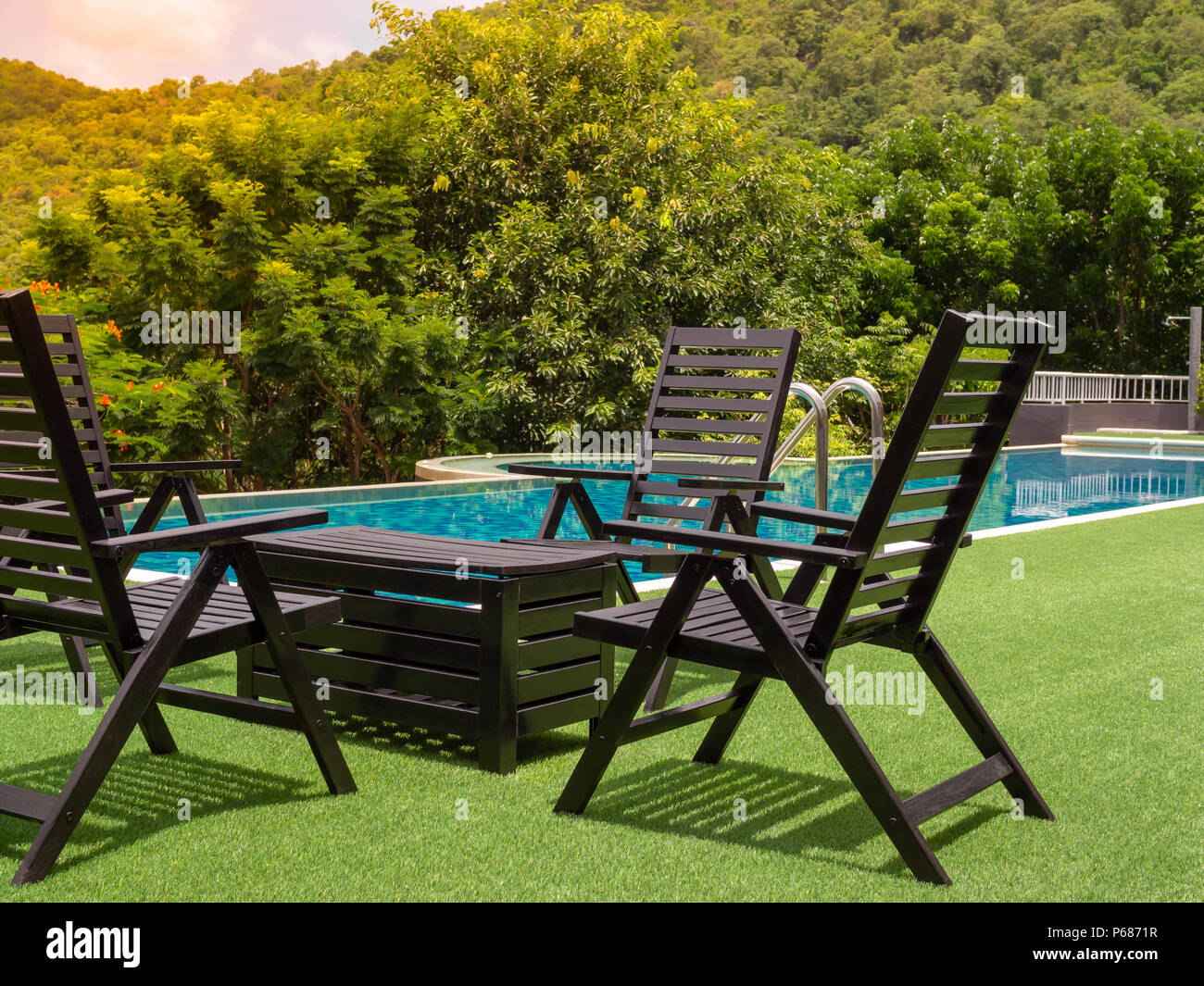 Swimming Pool with Wooden Table Set on Grass on Tree and Forest View ...