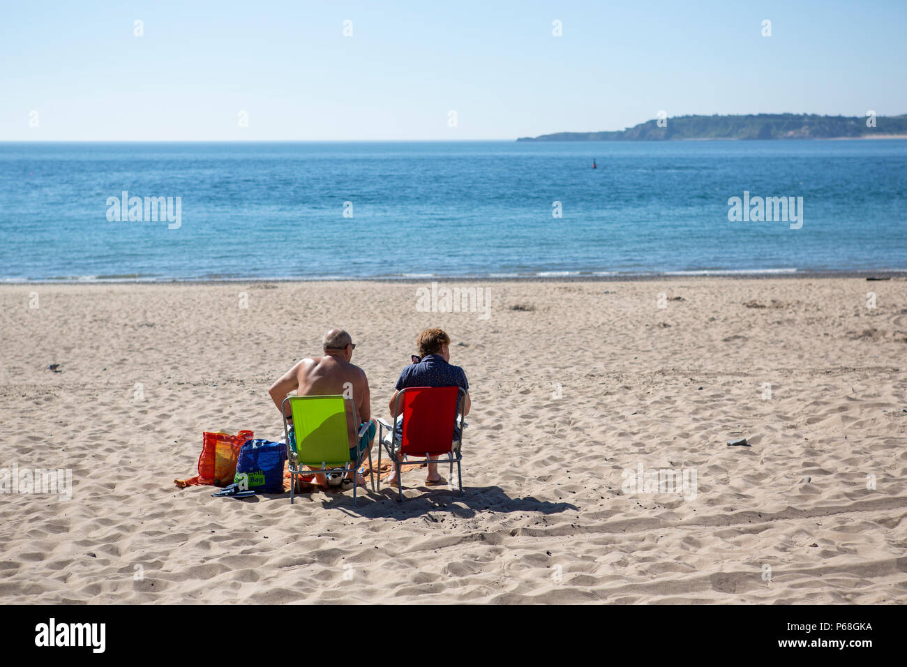 Tenby, Wales, UK. Friday 29 June 2018. A couple enjoy the hot weather ...