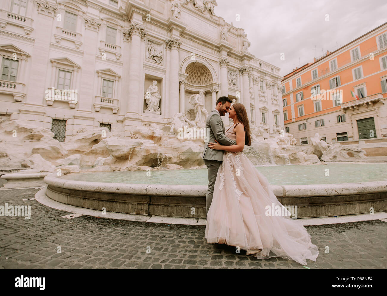 Just married bride and groom posing in front of Trevi Fountain (Fontana ...
