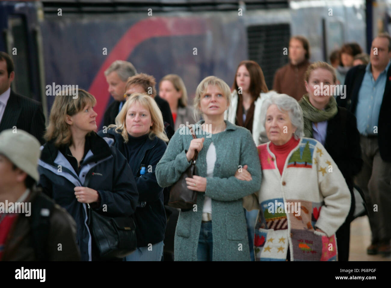These ladies check details of their train time during rush hour at ...