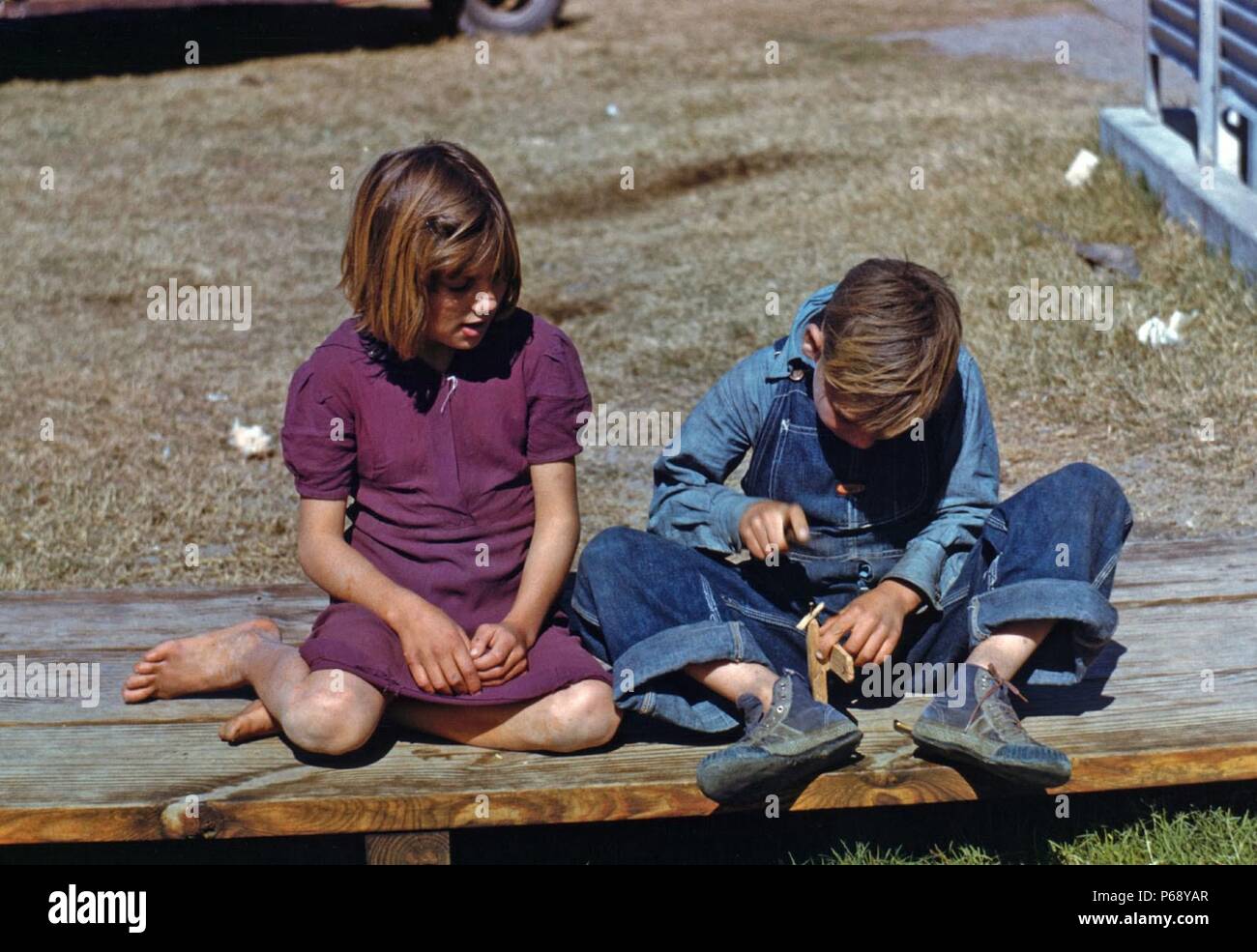 Photograph of Boy building a model airplane as girl watches ...