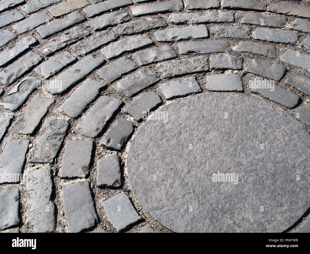 Granite sett cobbled paving in circle design Stock Photo - Alamy