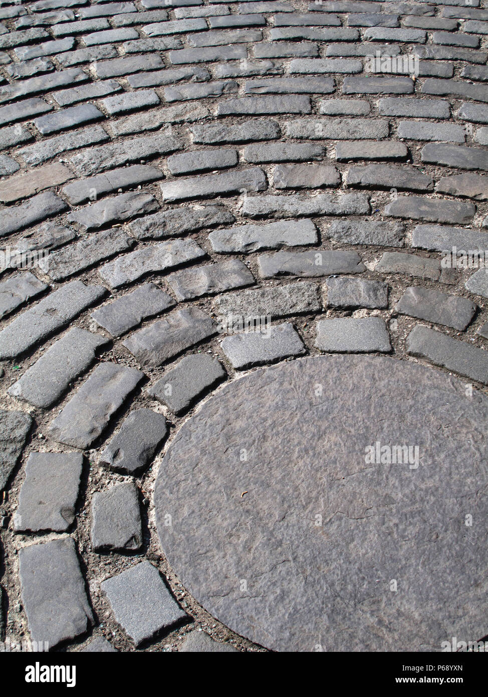 Granite sett cobbled paving in circle design Stock Photo - Alamy