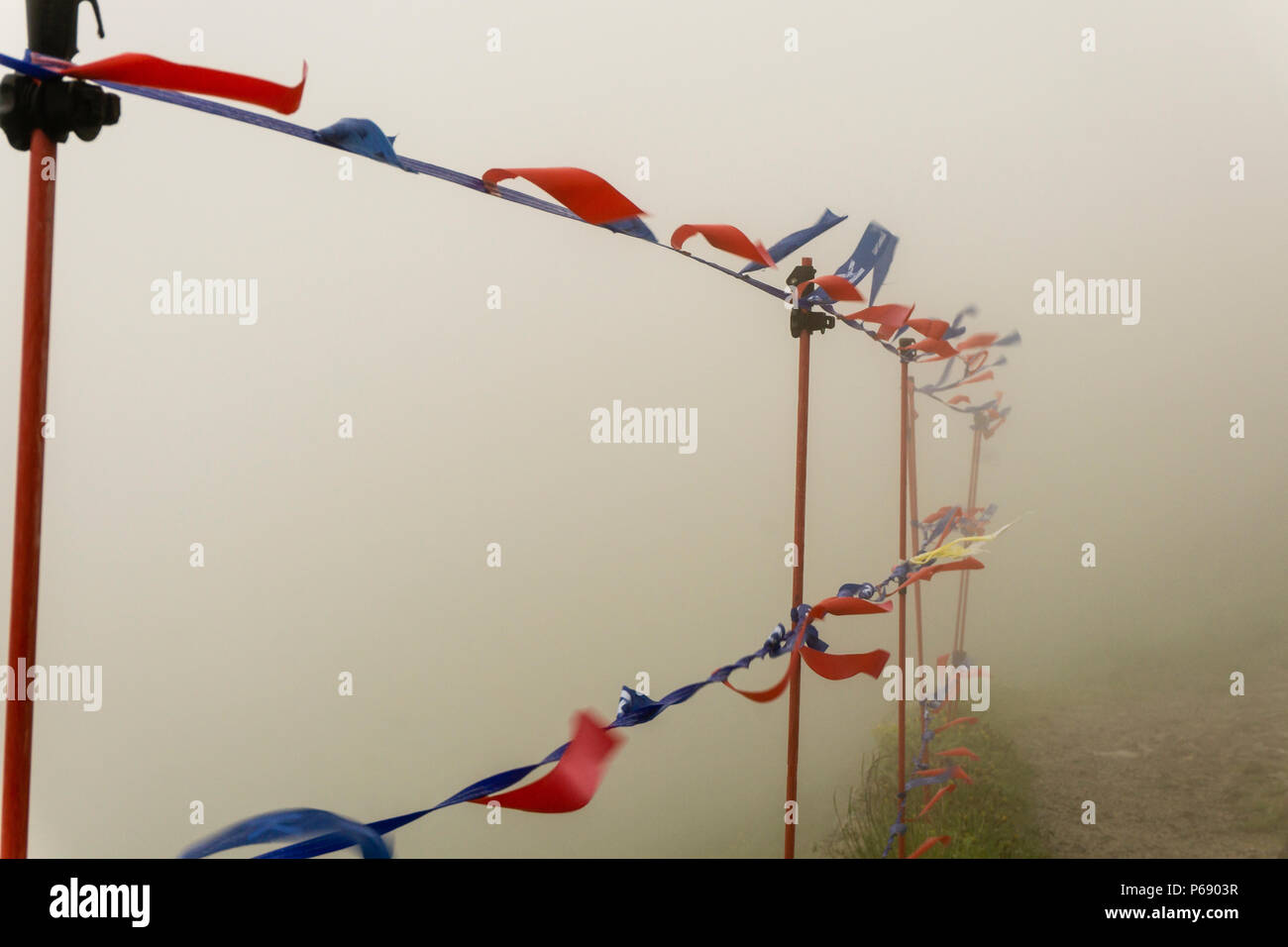 Barriers with flags in a strong wind Stock Photo - Alamy