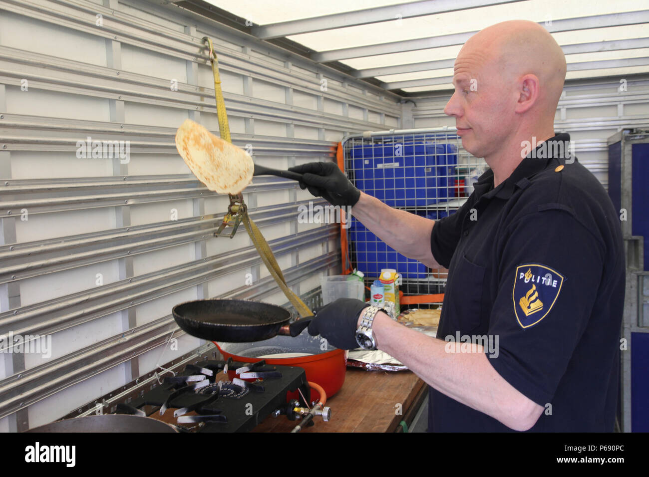 A Luxembourg police officer prepares pancakes for marching participants ...