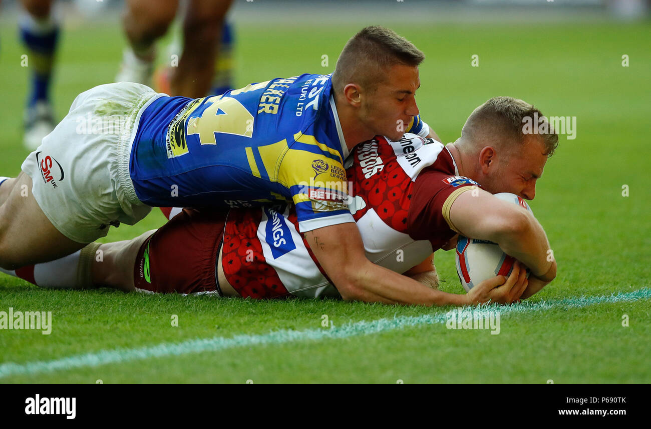 Wigan Warriors Josh Woods goes past Leeds Rhinos Jack Walker to score a ...