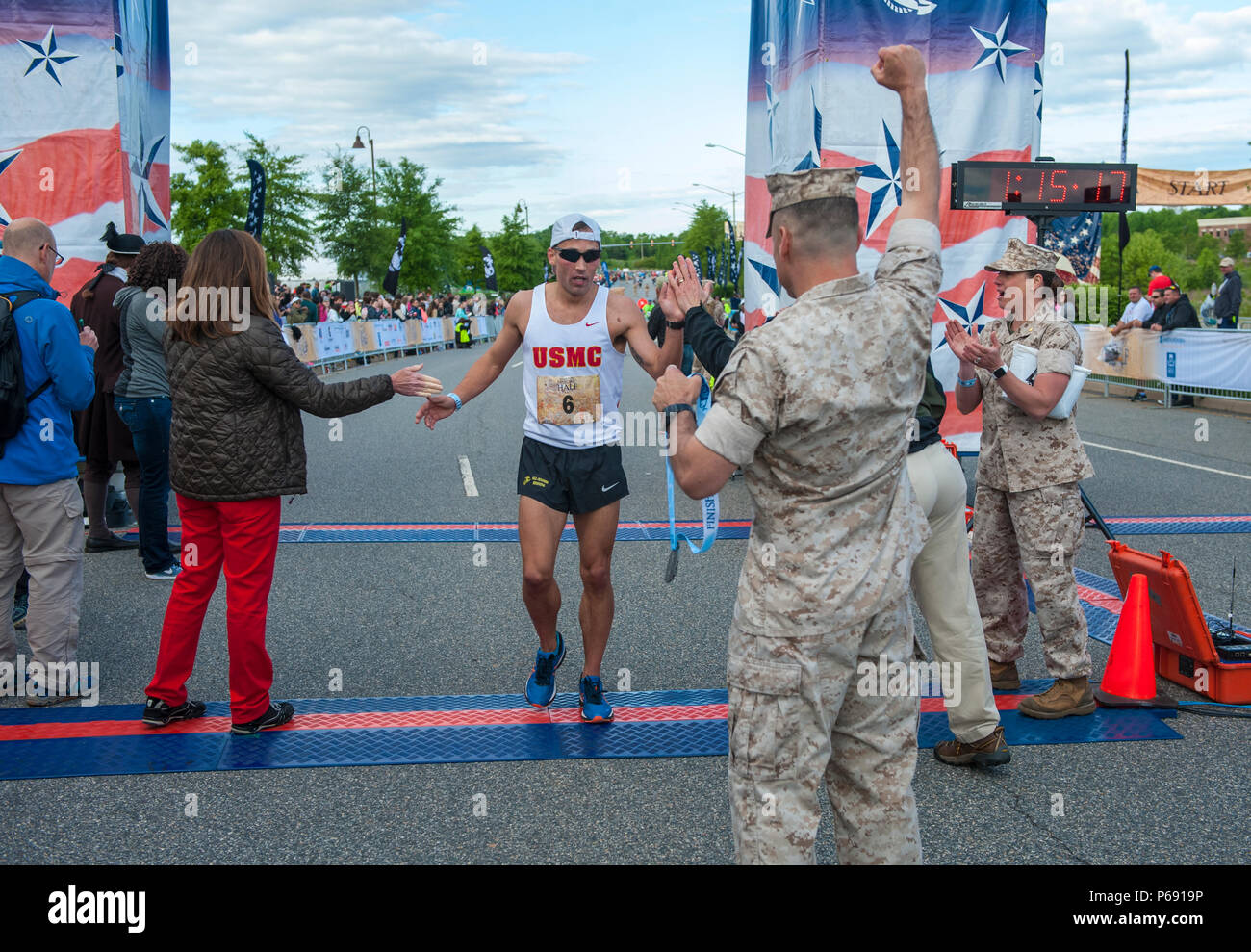 Calum Ramm crosses the finish line and receives a medal from Marine ...