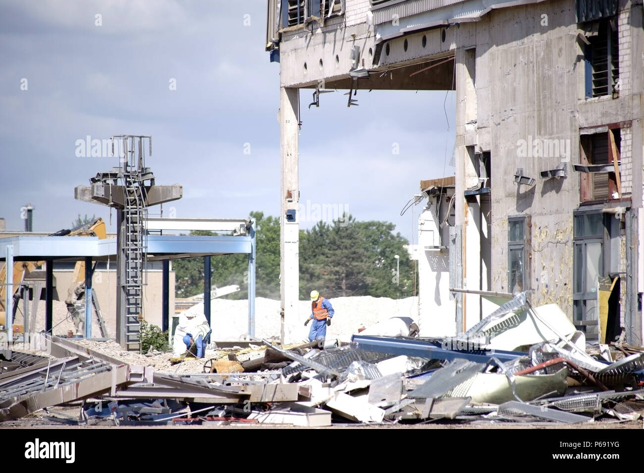 Two construction workers sort the rubble from demolition work of an ...