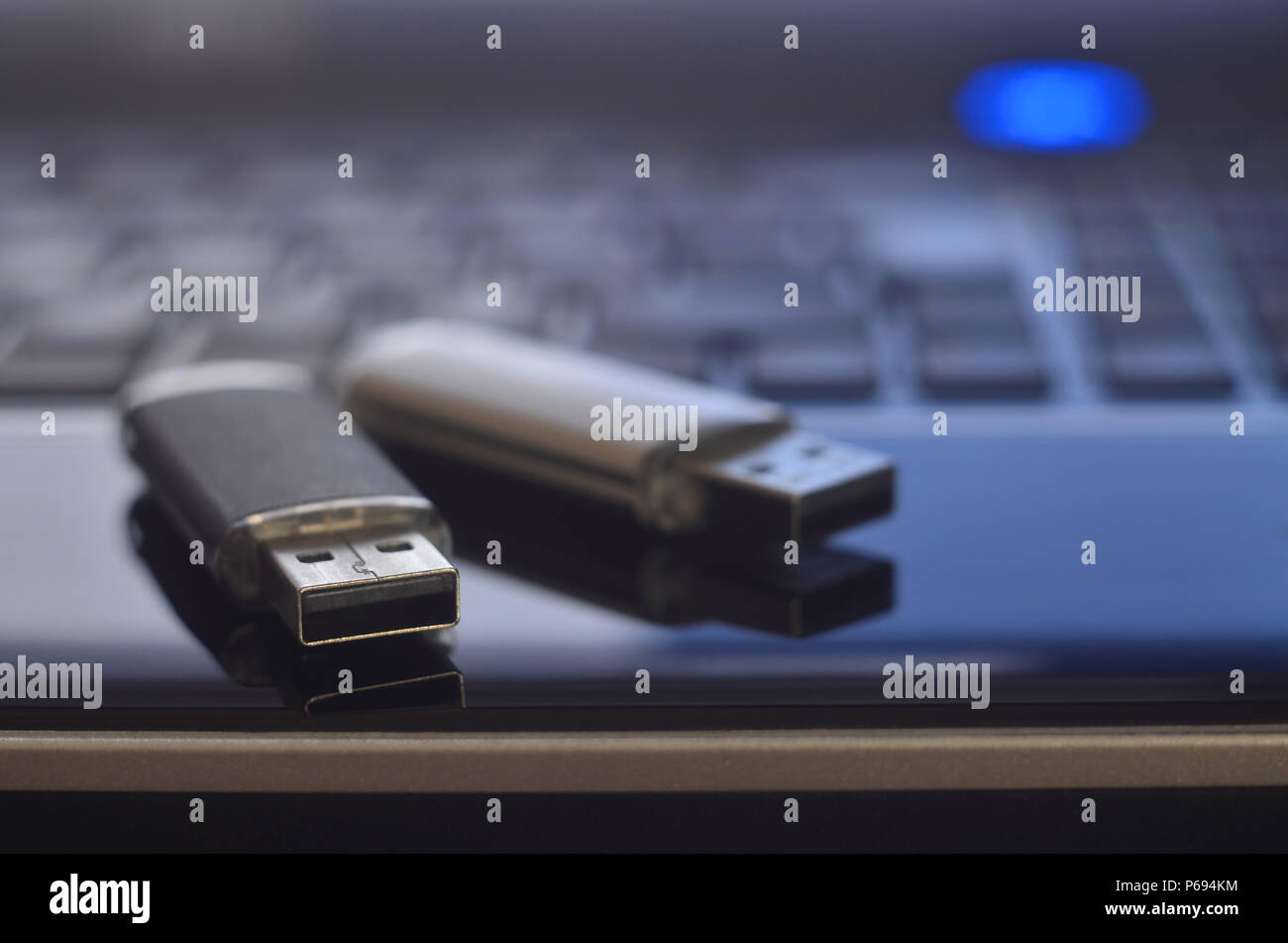 USB flash cards lying on black laptop case in front of his keyboard ...