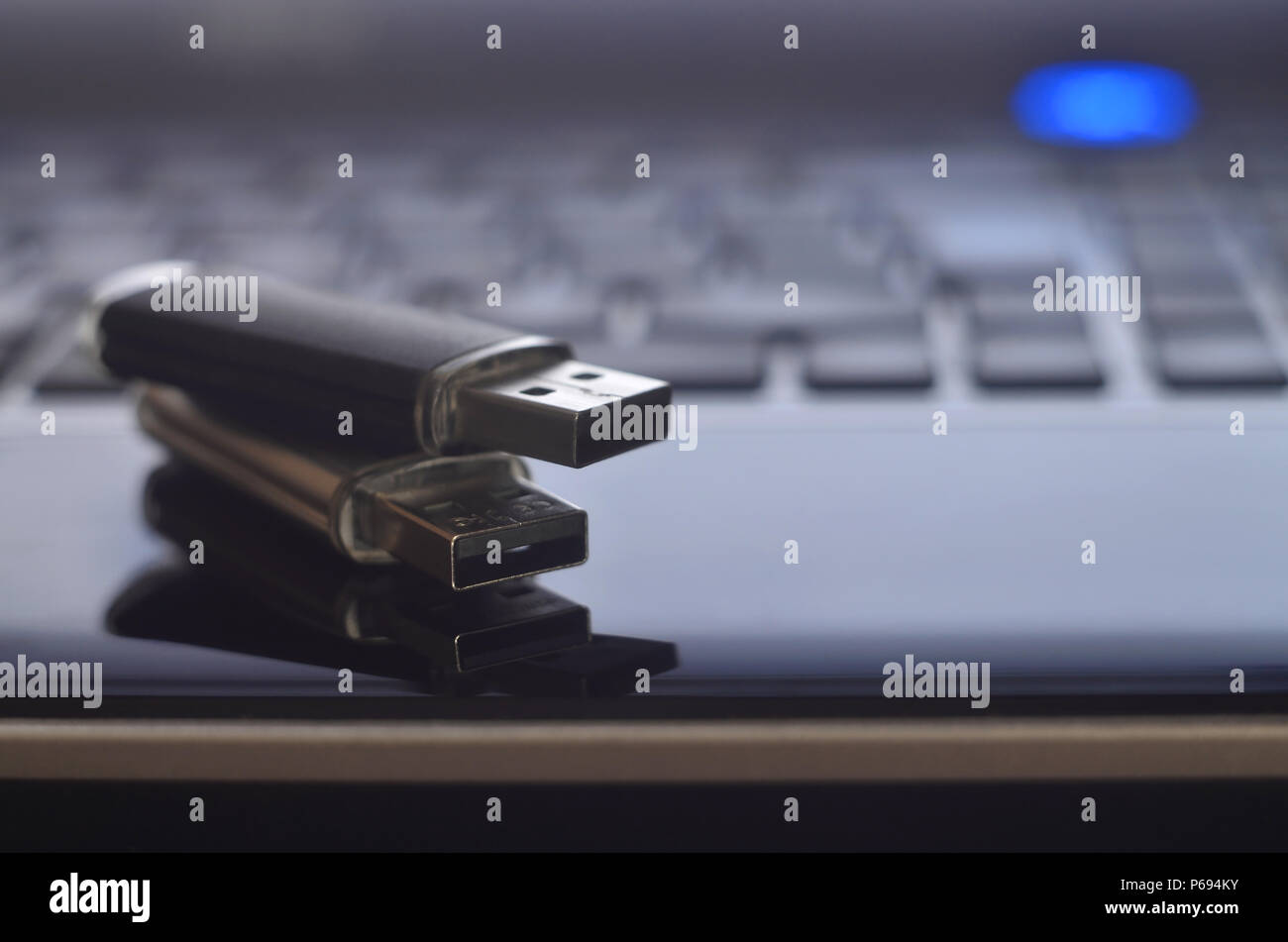 USB flash cards lying on black laptop case in front of his keyboard ...