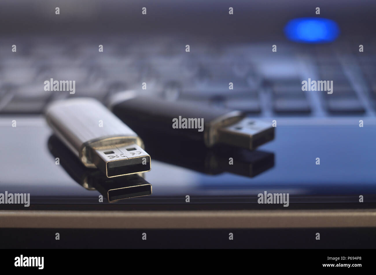 USB flash cards lying on black laptop case in front of his keyboard ...