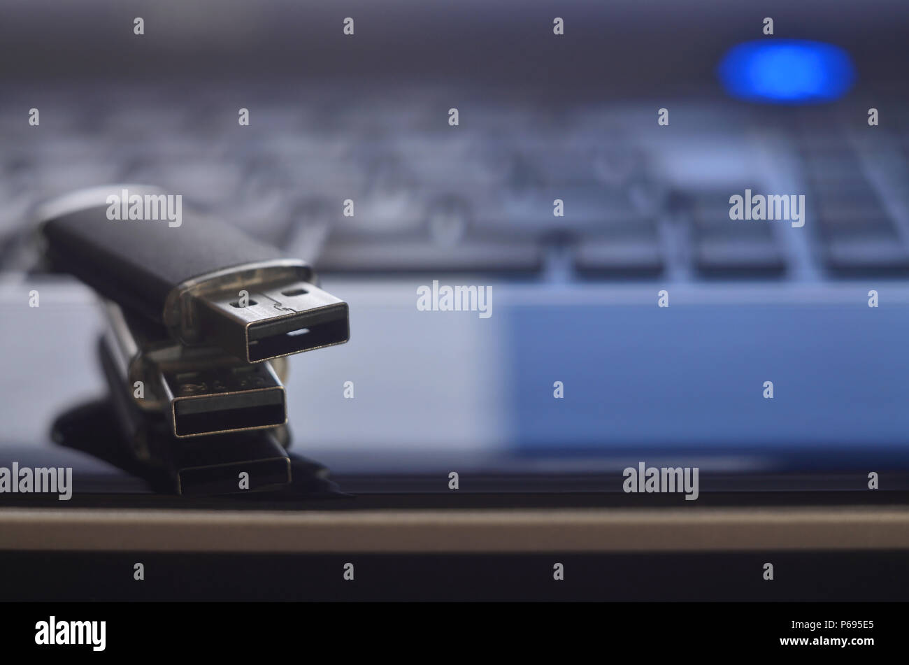 USB flash cards lying on black laptop case in front of his keyboard ...