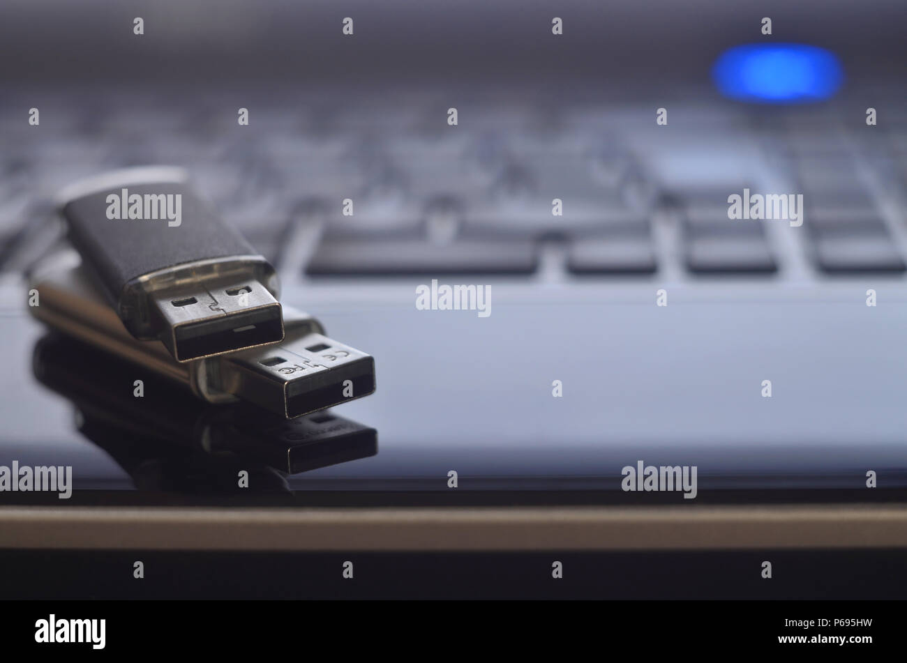 USB flash cards lying on black laptop case in front of his keyboard ...