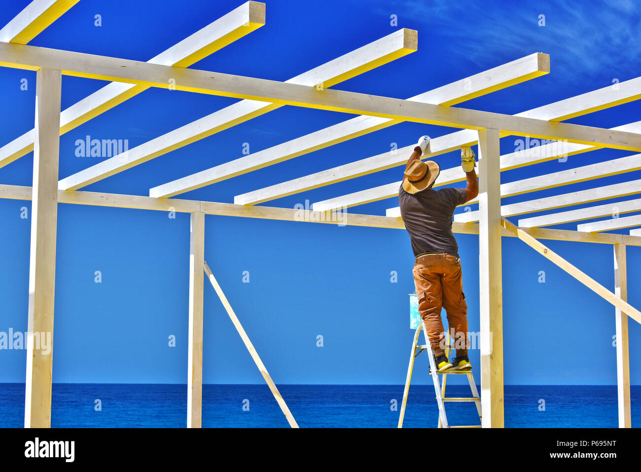 Man putting a wooden structure on the beach Stock Photo - Alamy