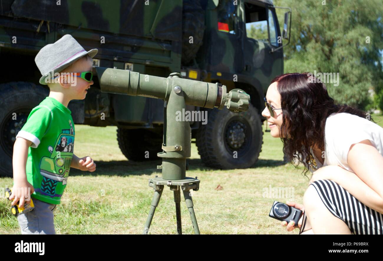 A Latvian mother and her son look into a M1A2 Collimator during the ...