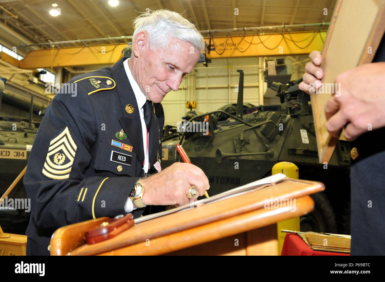 Retired Command Sgt. Maj. Harvey Reed signs his name in the rolls of ...