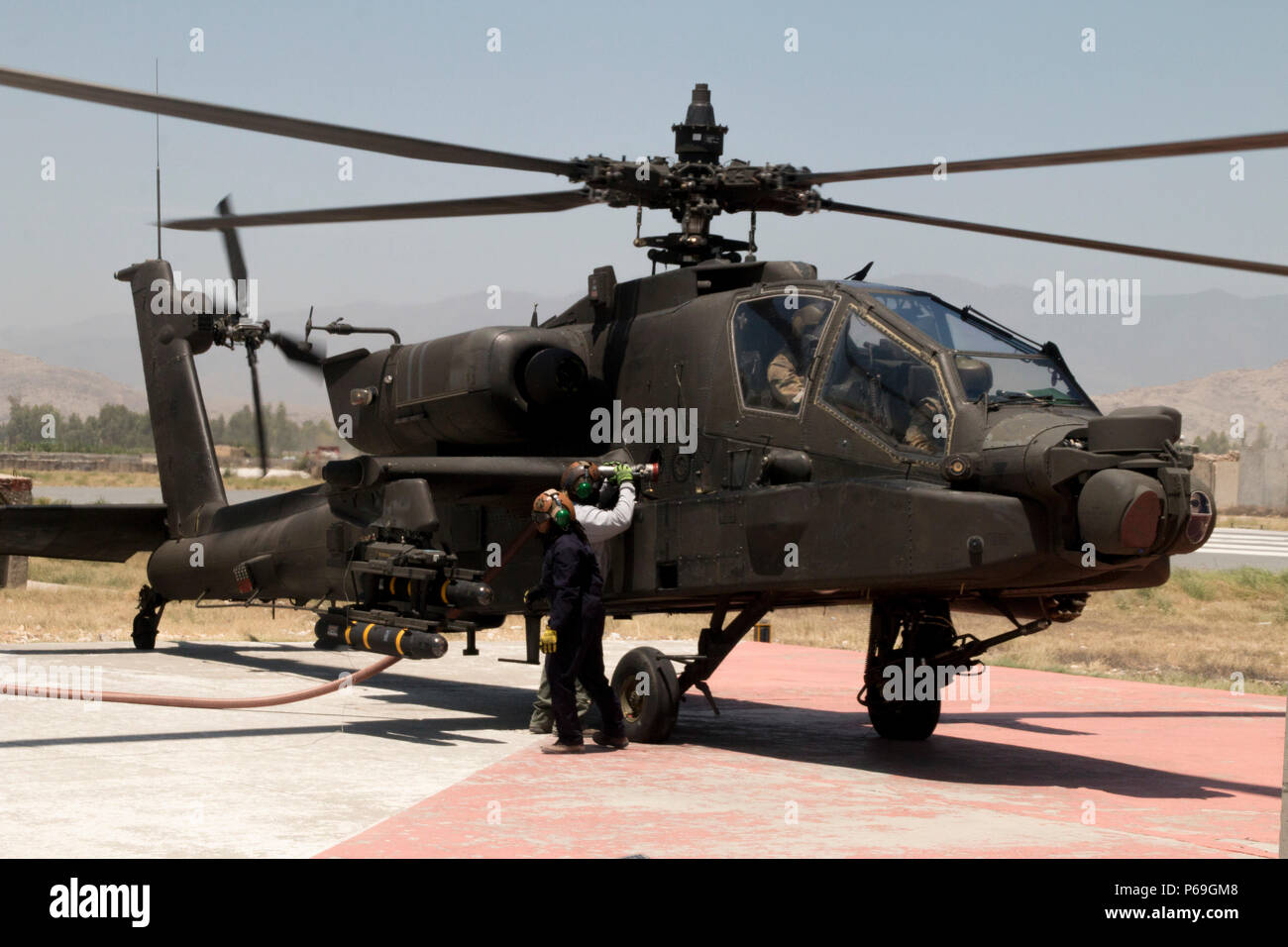 A U.S. Army AH-64 Apache helicopter receives a hot refuel at Forward ...