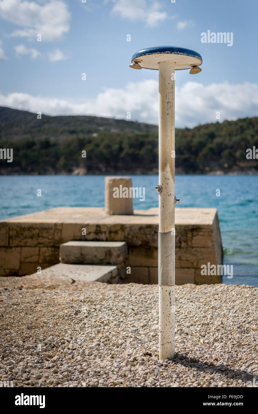 Shower on the beach, berth with bollard in the background, Cres Croatia ...