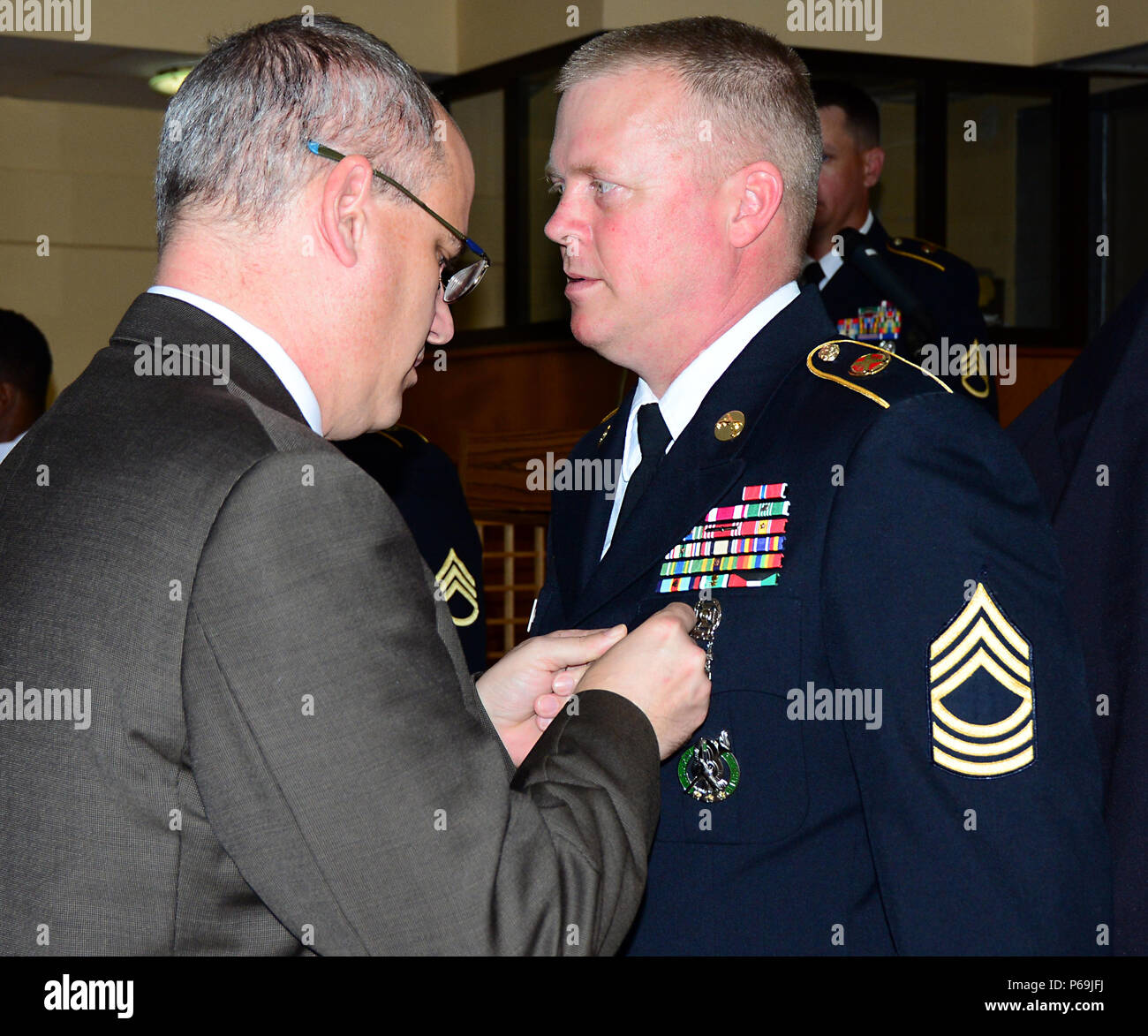Mr. David J. Leinberger, Deputy Garrison Manager U.S. Army Garrison Italy, left, awards the MSM ...