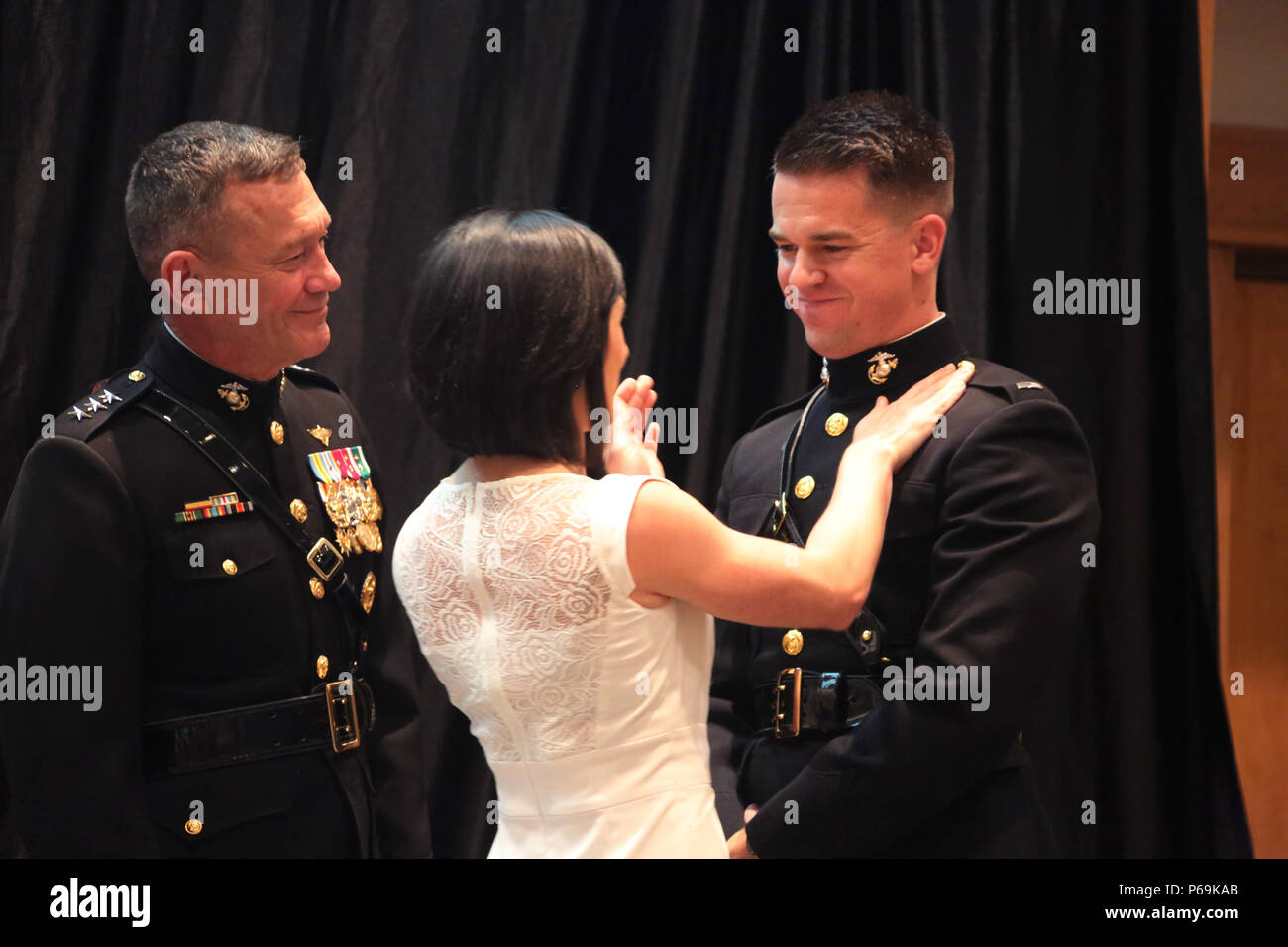 A Marine Corps aviator is pinned by his wife during a winging ceremony ...