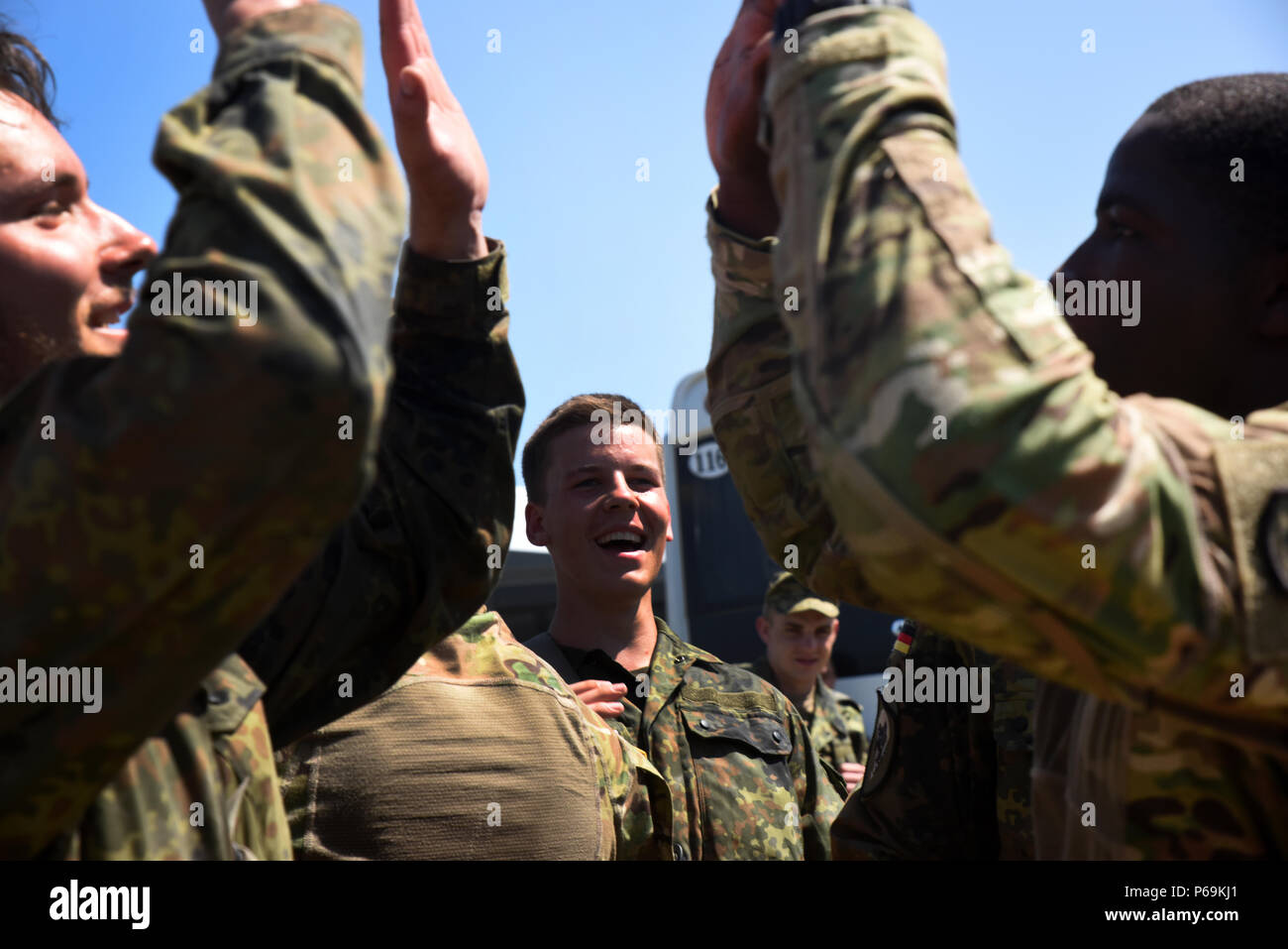 A German Soldier laughs as U.S. and German Soldiers high-five after a ...