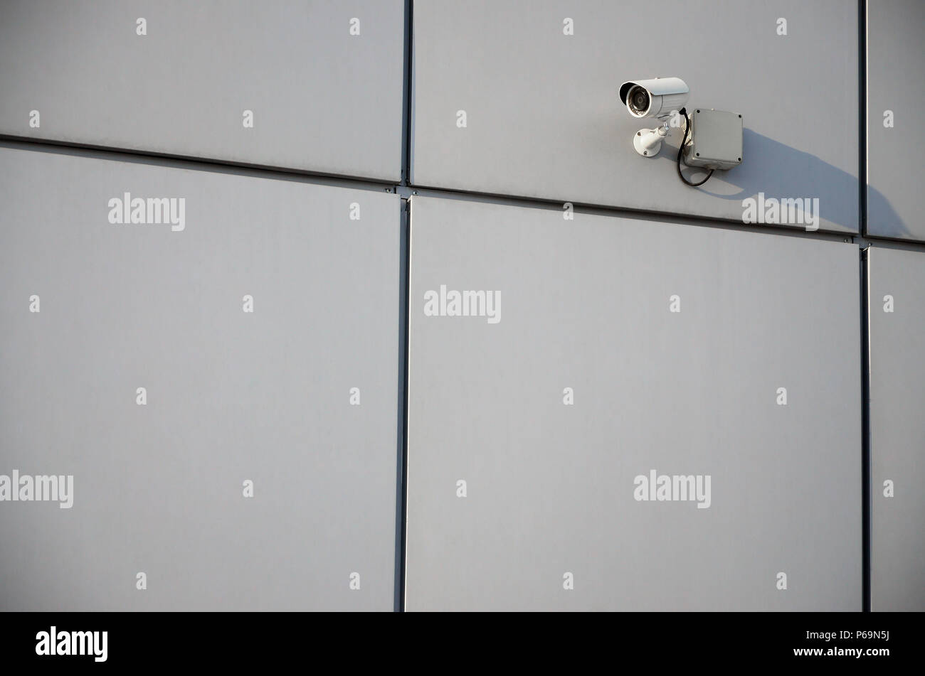White surveillance camera built into the metal wall of the office ...