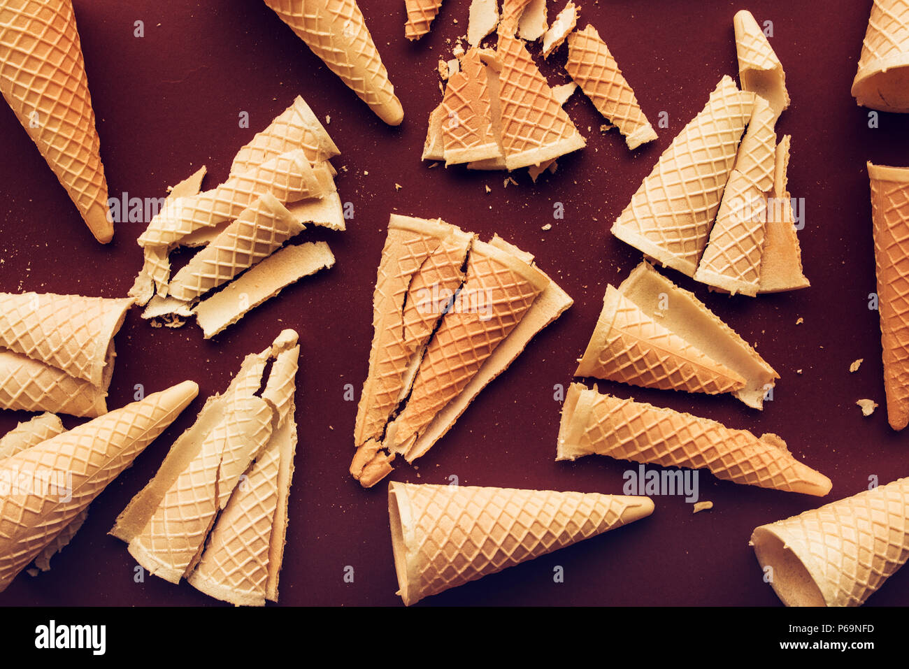 Crushed ice cream waffle cones on dark brown background, flat lay Stock ...