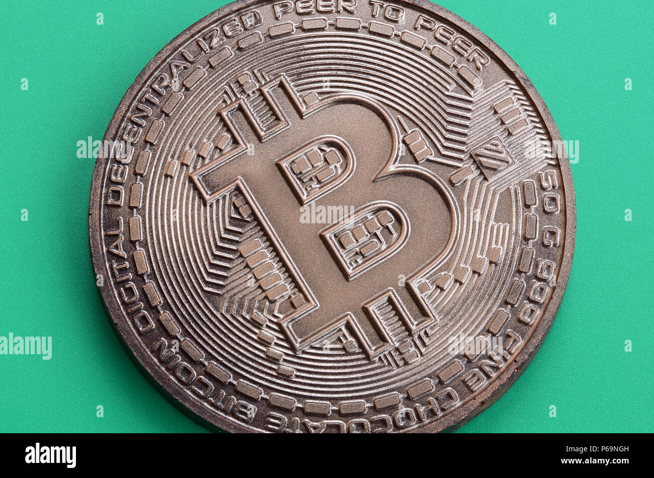Chocolate product in the form of physical bitcoin lies on a green ...