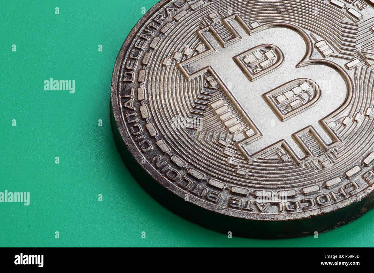 Chocolate product in the form of physical bitcoin lies on a green ...