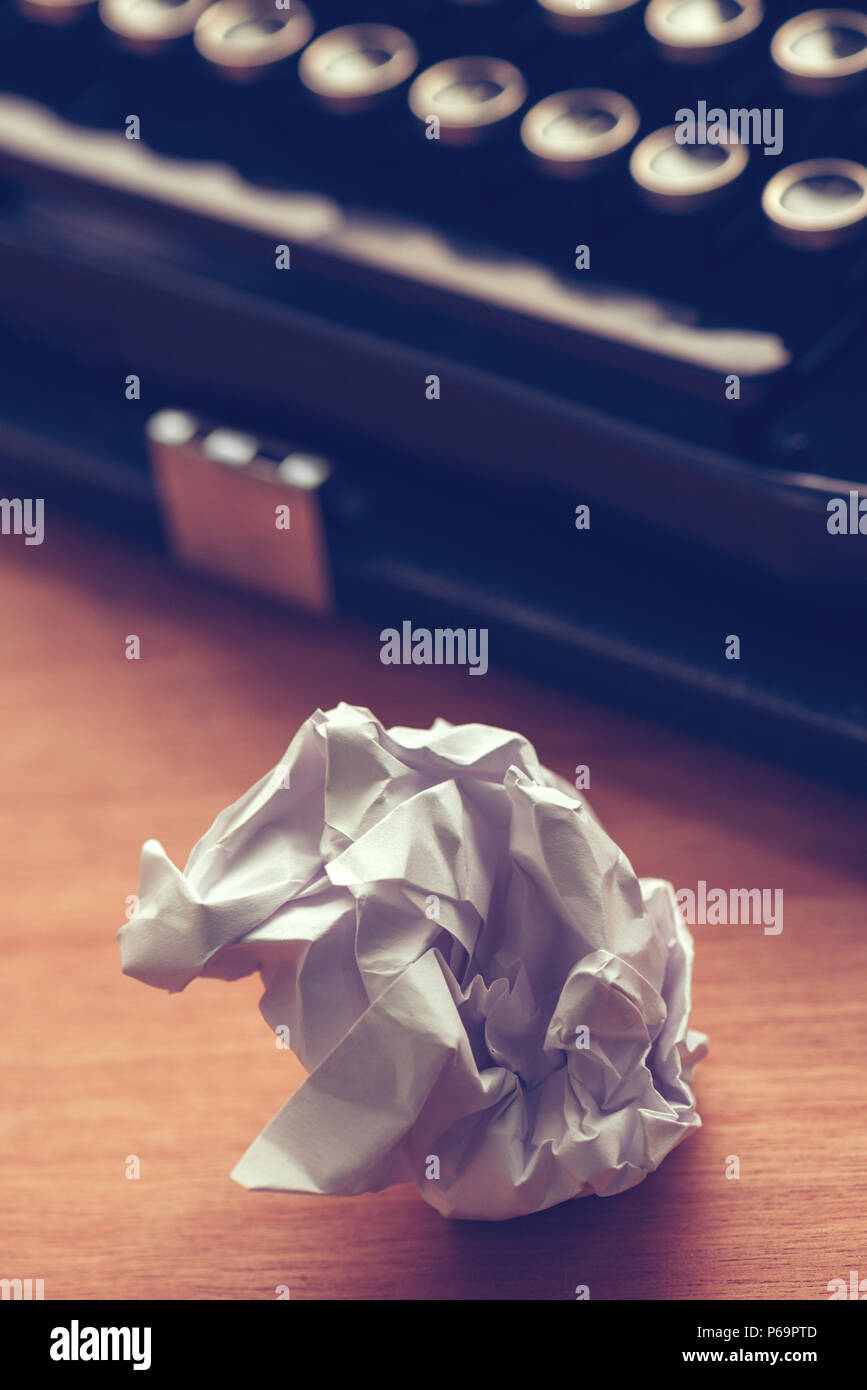 Writer's block concept with typewriter and crumpled paper on work desk ...