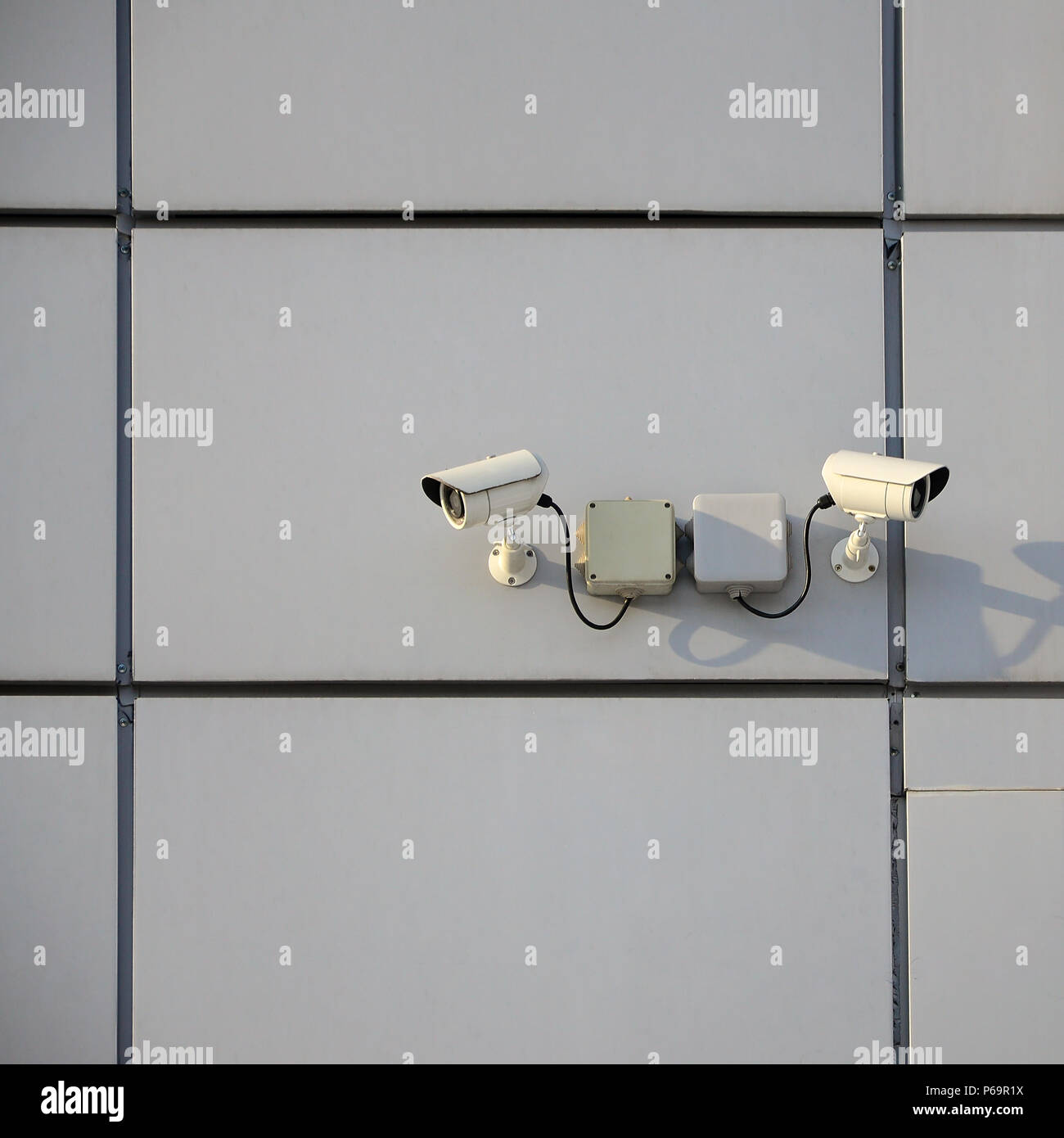 White surveillance camera built into the metal wall of the office ...