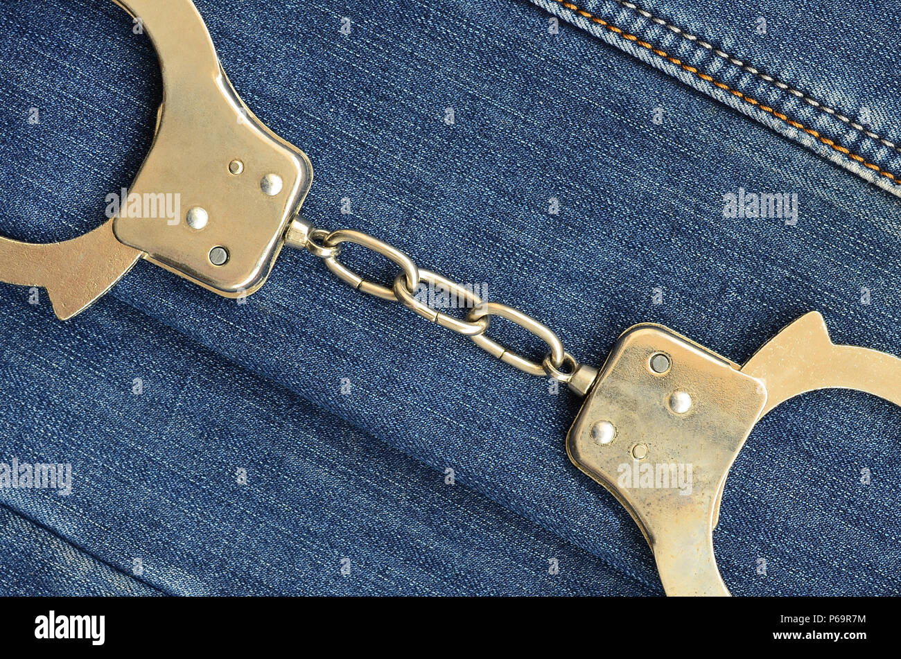 Police steel handcuffs lying on dark blue jeans background Stock Photo ...