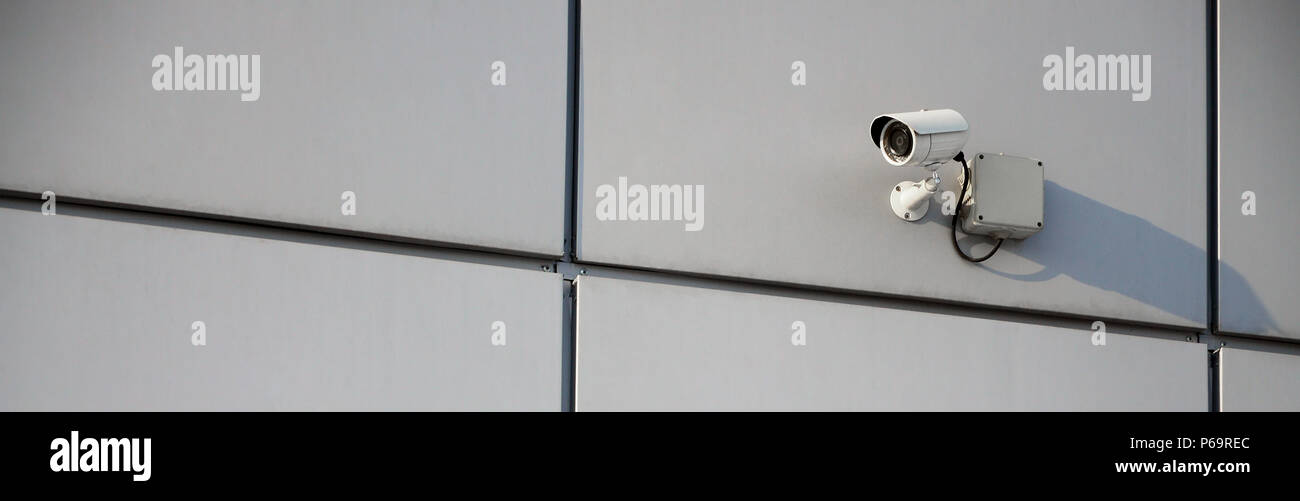 White surveillance camera built into the metal wall of the office ...
