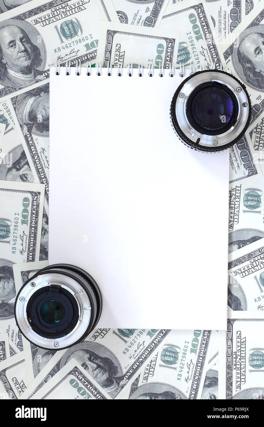 Two photographic lenses and white notebook lie on the background of a ...