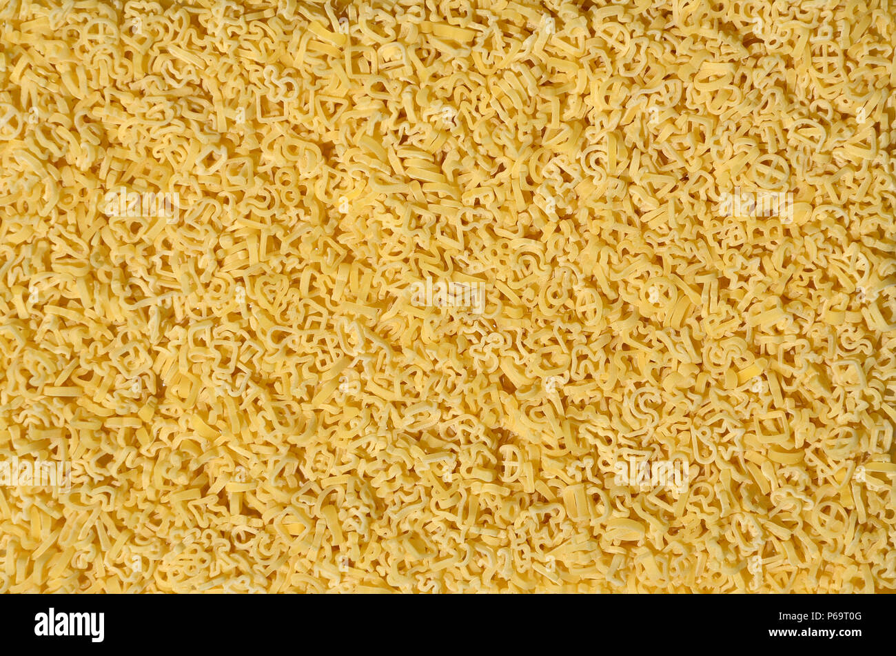 Texture of a lot of curly raw yellow pasta Stock Photo - Alamy