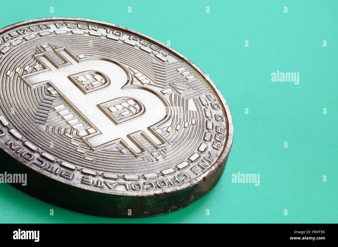 Chocolate product in the form of physical bitcoin lies on a green ...