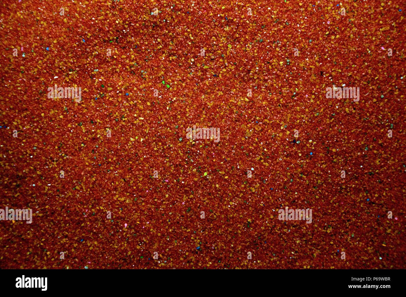 Texture of a colored granular sand close up. Red grains Stock Photo - Alamy