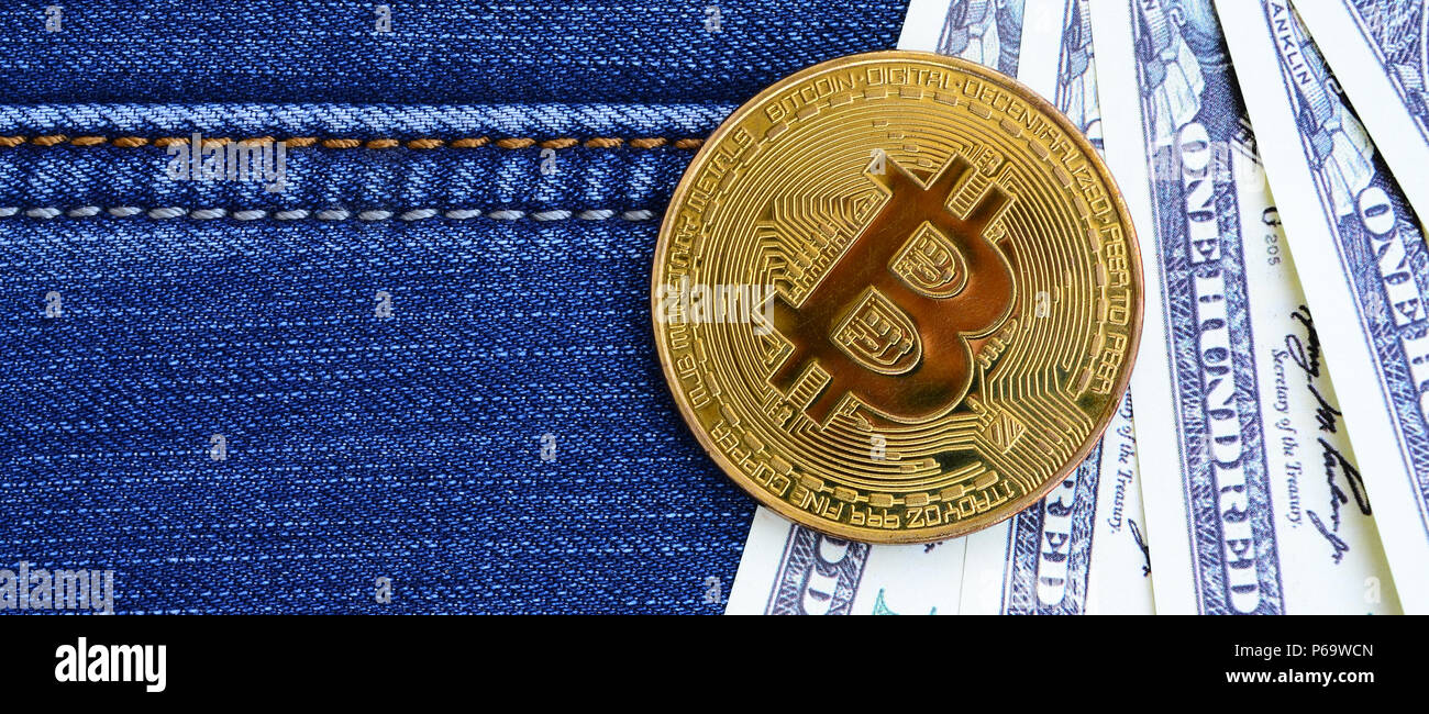 Golden Bitcoin and dollar bills lies on a blue jeans fabric. New ...