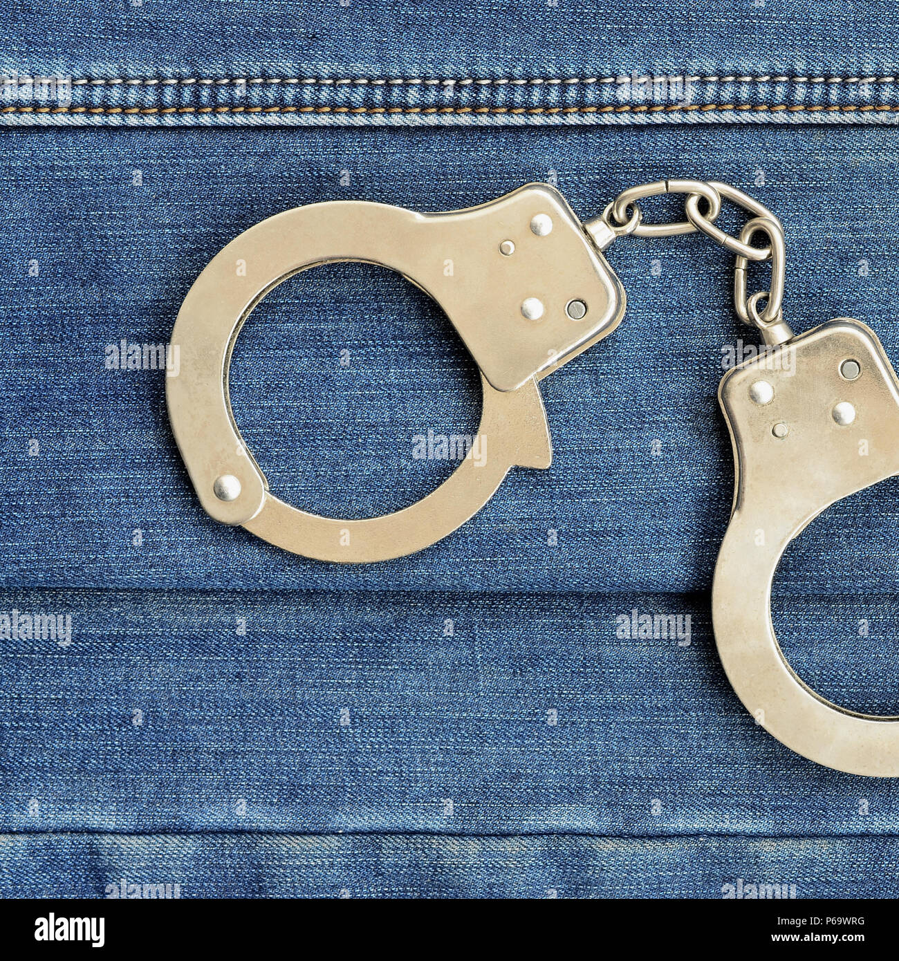 Police steel handcuffs lying on dark blue jeans background Stock Photo ...