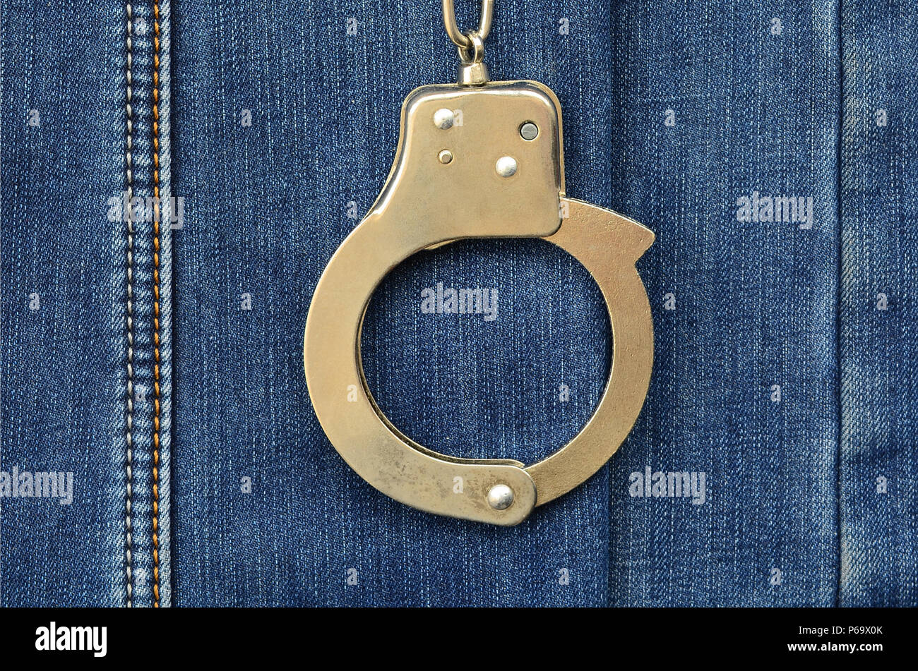 Police steel handcuffs lying on dark blue jeans background Stock Photo ...