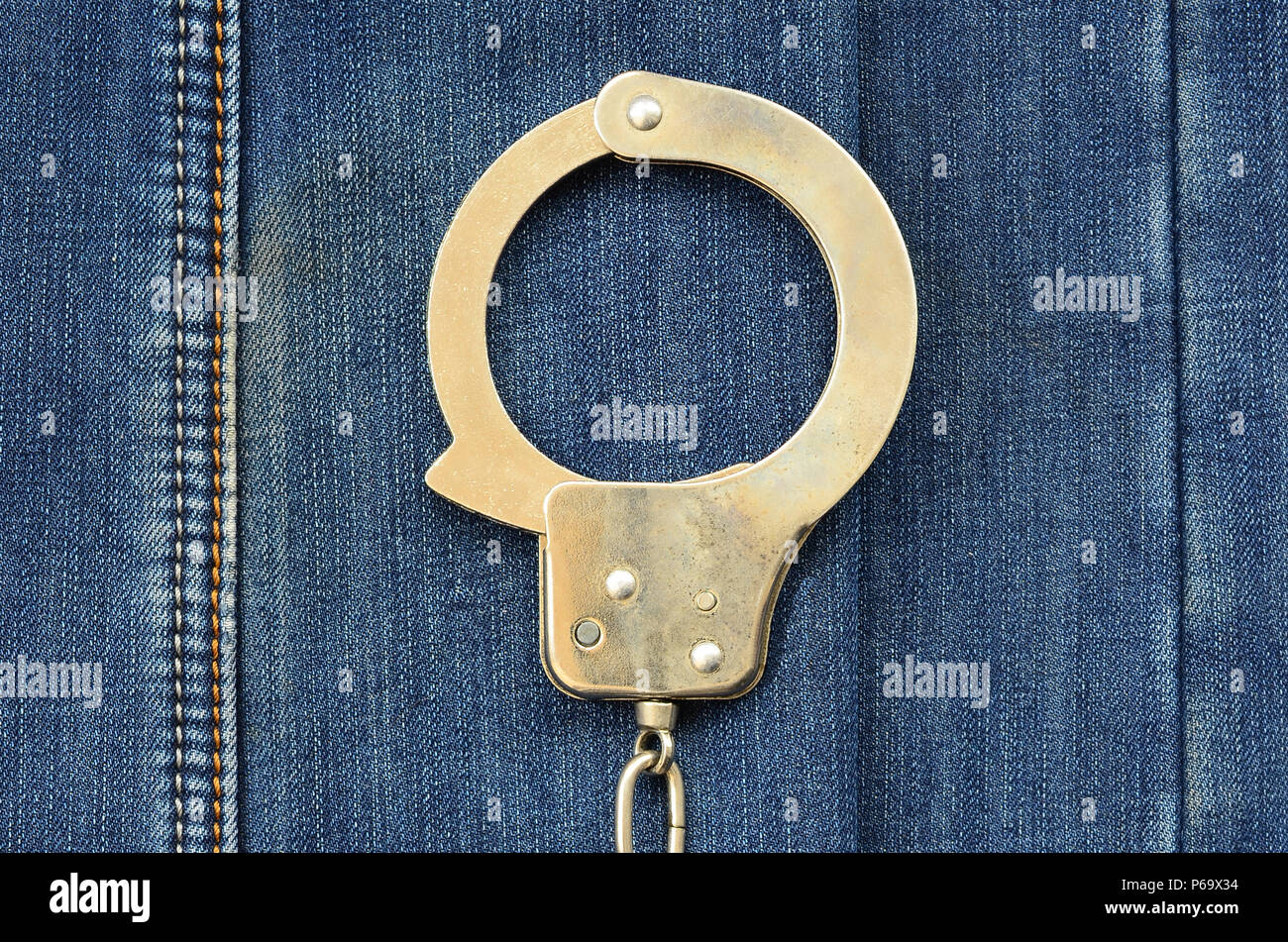 Police steel handcuffs lying on dark blue jeans background Stock Photo ...