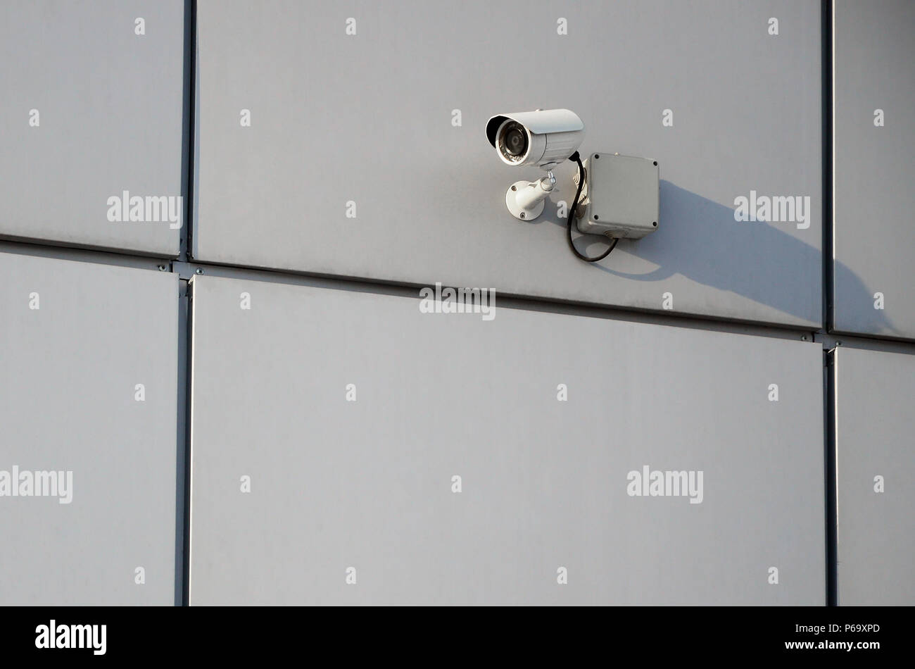 White surveillance camera built into the metal wall of the office ...