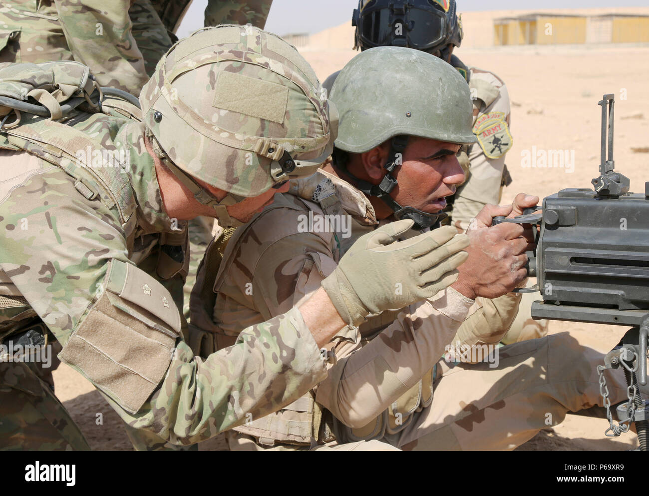 A Royal Danish Army soldier instructs an Iraqi soldier, with the 7th ...