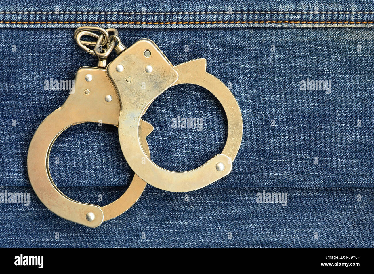 Police steel handcuffs lying on dark blue jeans background Stock Photo ...