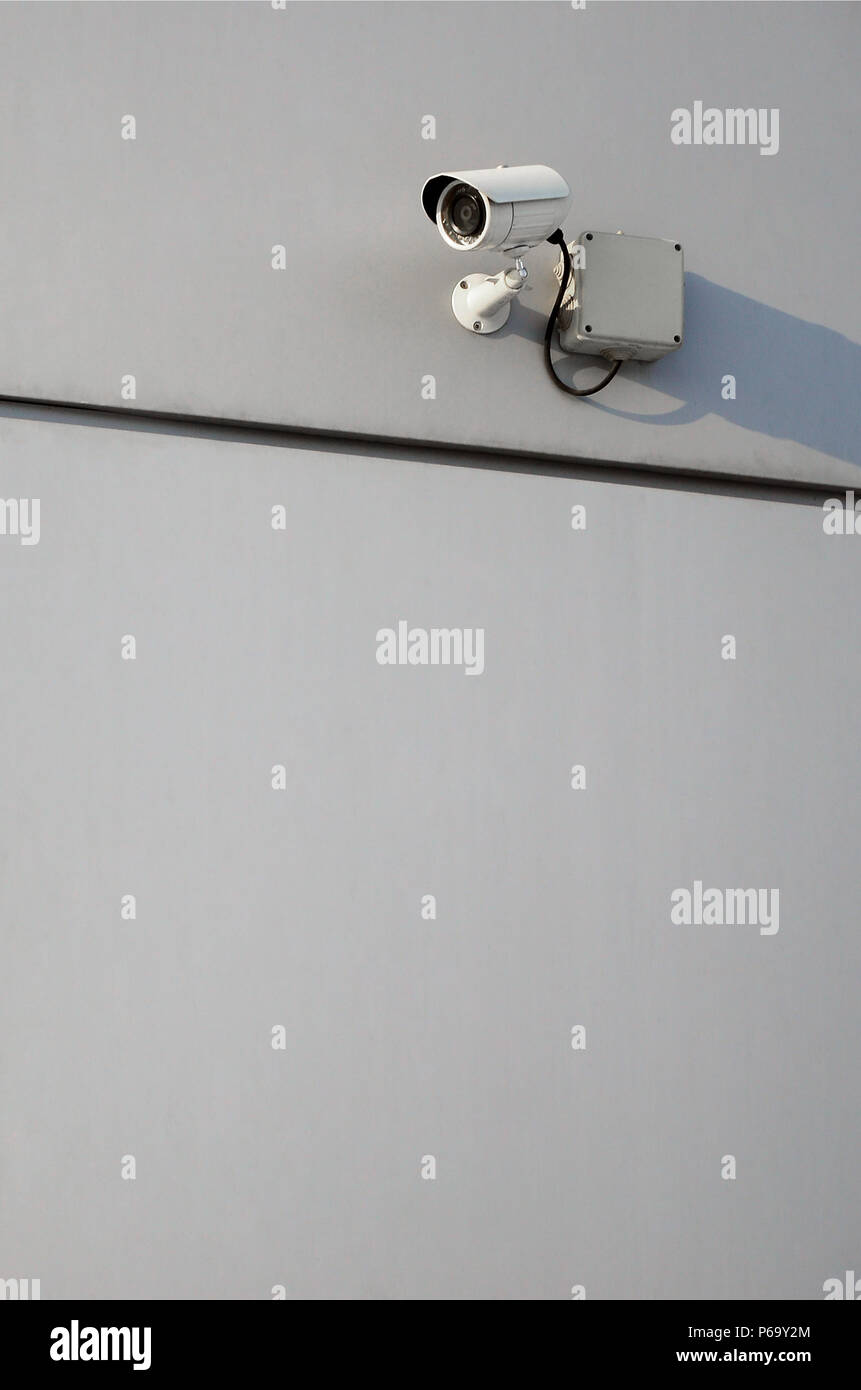 White surveillance camera built into the metal wall of the office ...