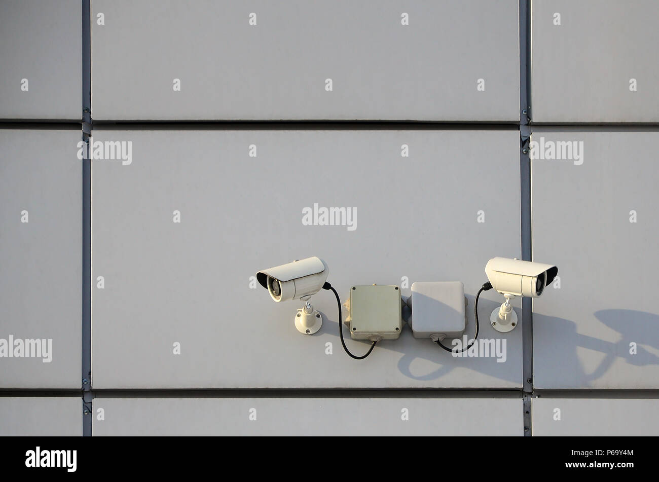 White surveillance camera built into the metal wall of the office ...